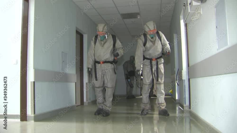 Military personnel in chemical protection suits carry out disinfection ...
