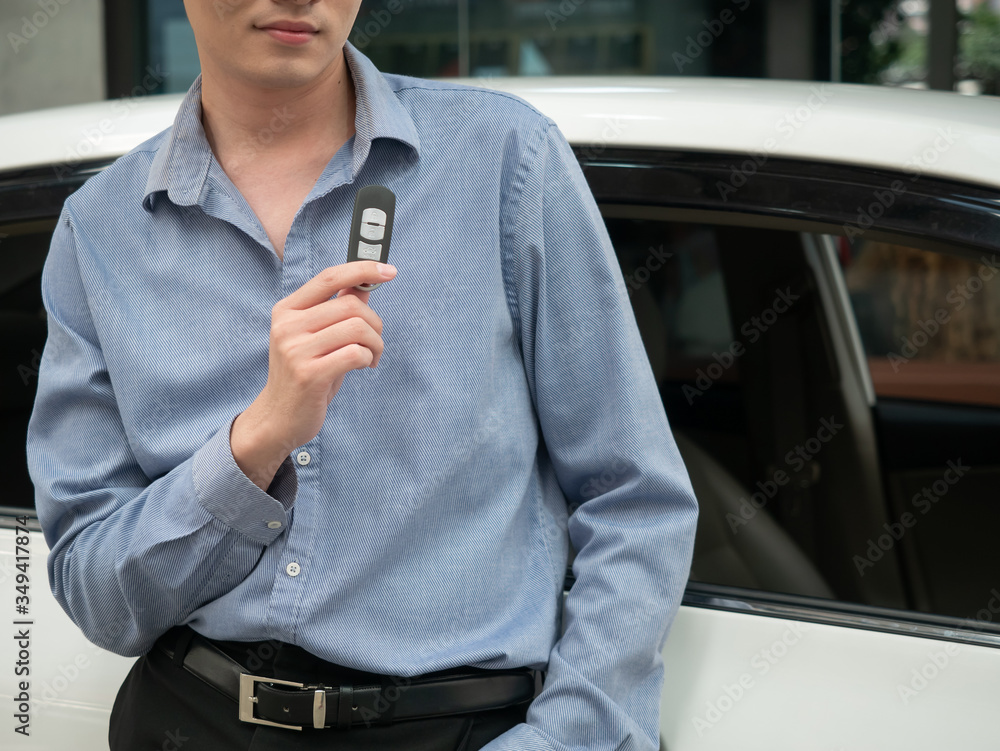 Man holding key in modern auto dealership. Close up hand of cardealer ...