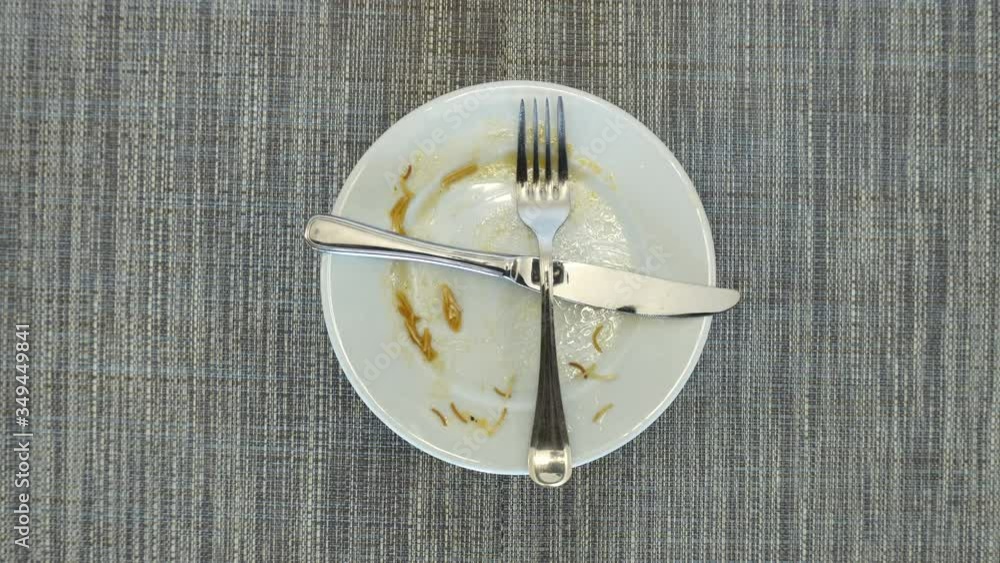 Top view, the plate rotates. On the plate remains of food, sauce. Dirty ...