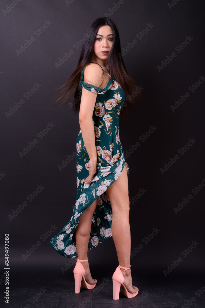 Full body shot of young beautiful Asian transgender woman looking back ...
