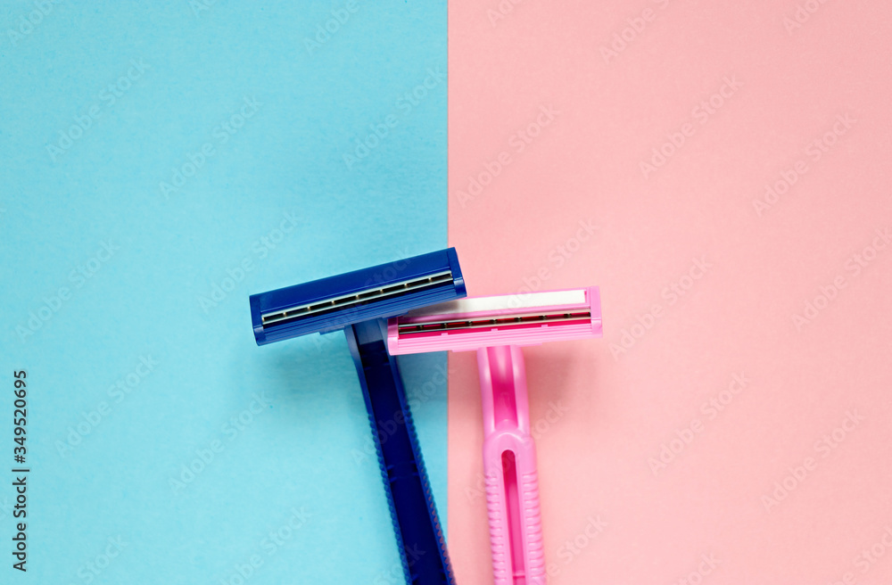 Top view two new disposable razors blue and pink are lying next to each ...