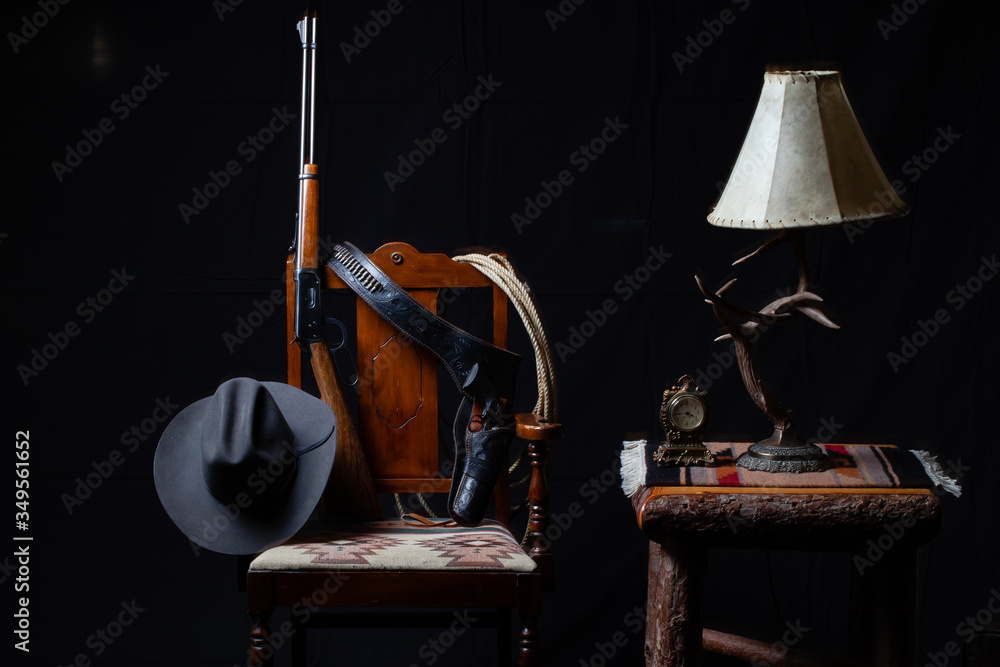Lever action rifle, revolver, rope, cowboy hat, clock, table, lamp and ...
