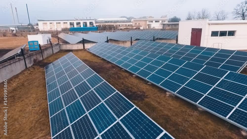 Field with solar batteries. Flying over the blue sunny batteries on the ...