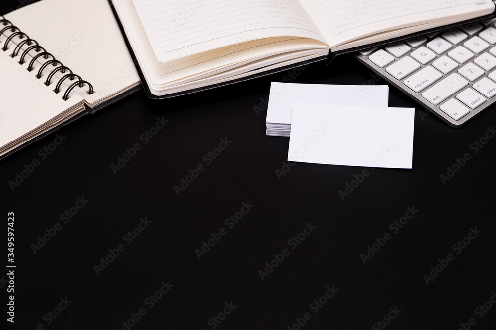 Flat lay of top view black work table with visiting cards and office ...