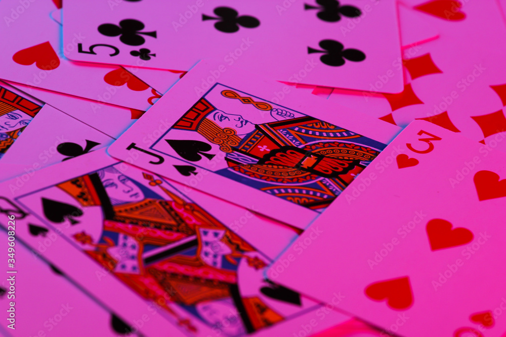 Playing cards in neon blue-pink light on black background. Game ...