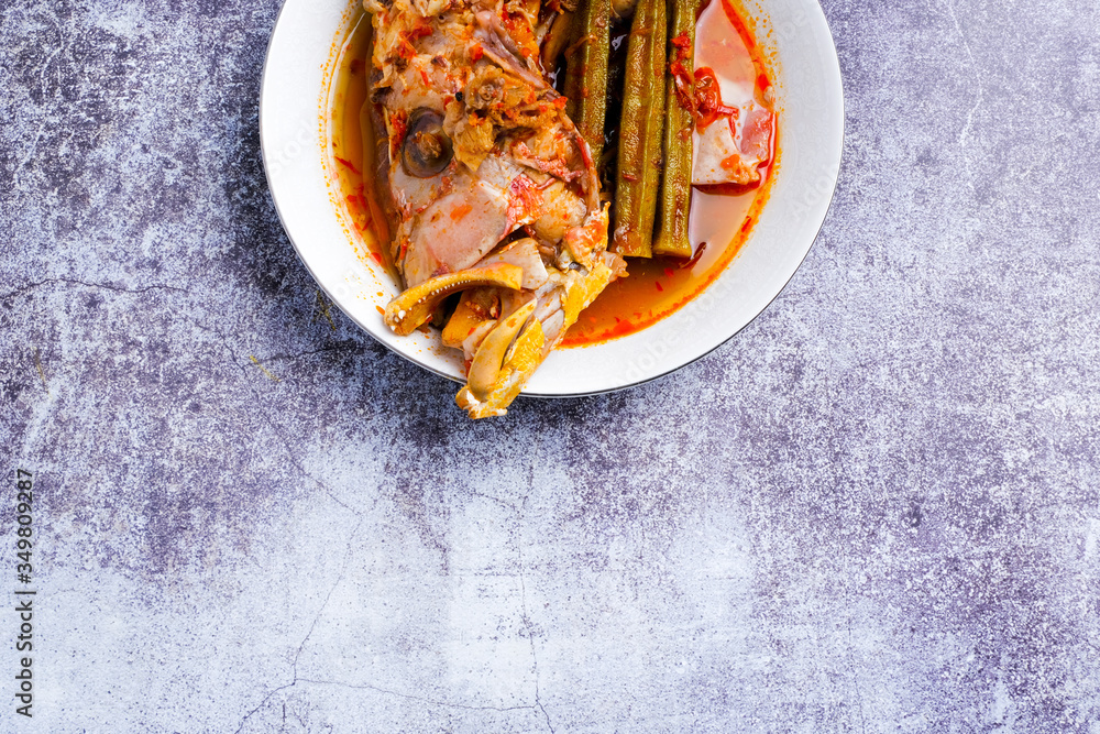 A close up picture part of red snapper head in "asam pedas". With ...