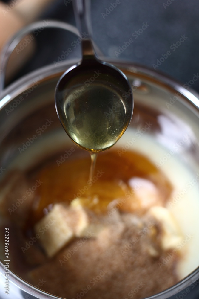 Adding golden syrup into pan with filling ingredients. Making Boston ...