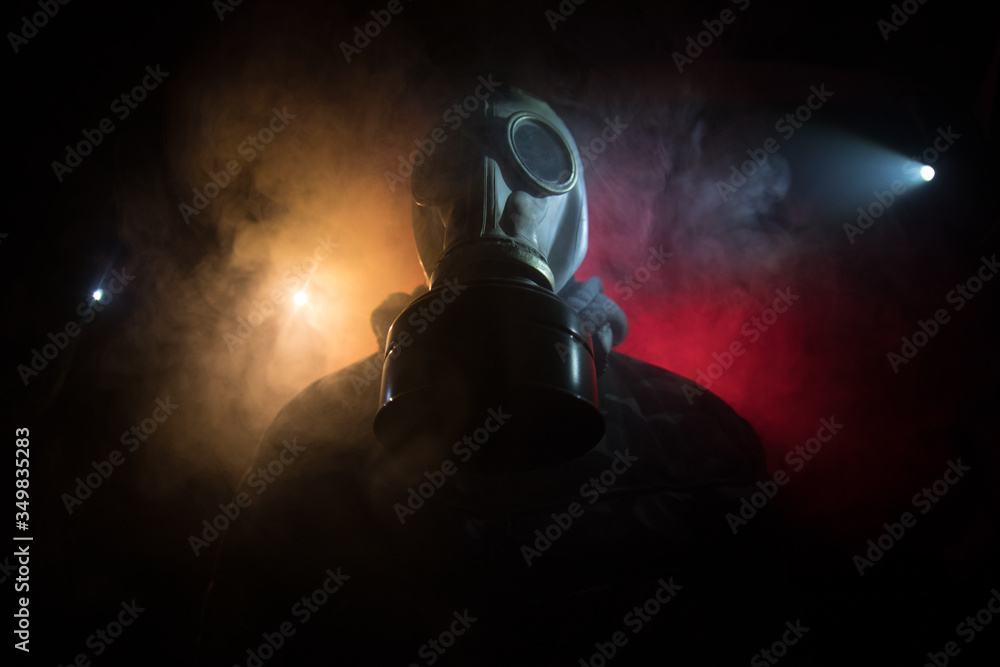 Gas mask with clouds of smoke on a dark background. Sign of radioactive ...