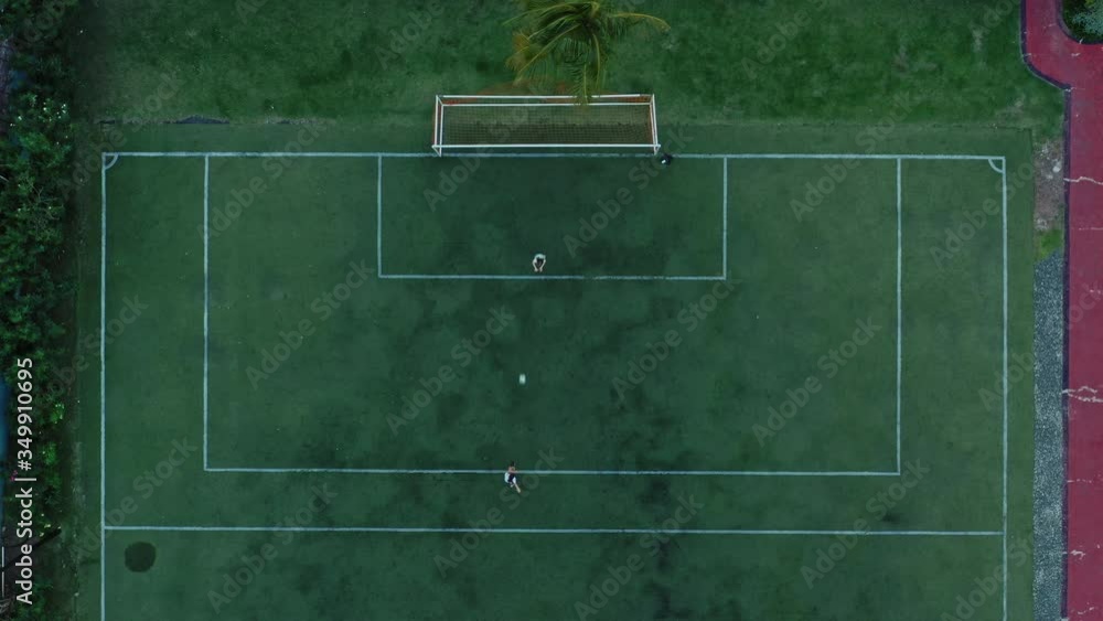 Drone top shot of two people playing soccer and practicing penalty ...