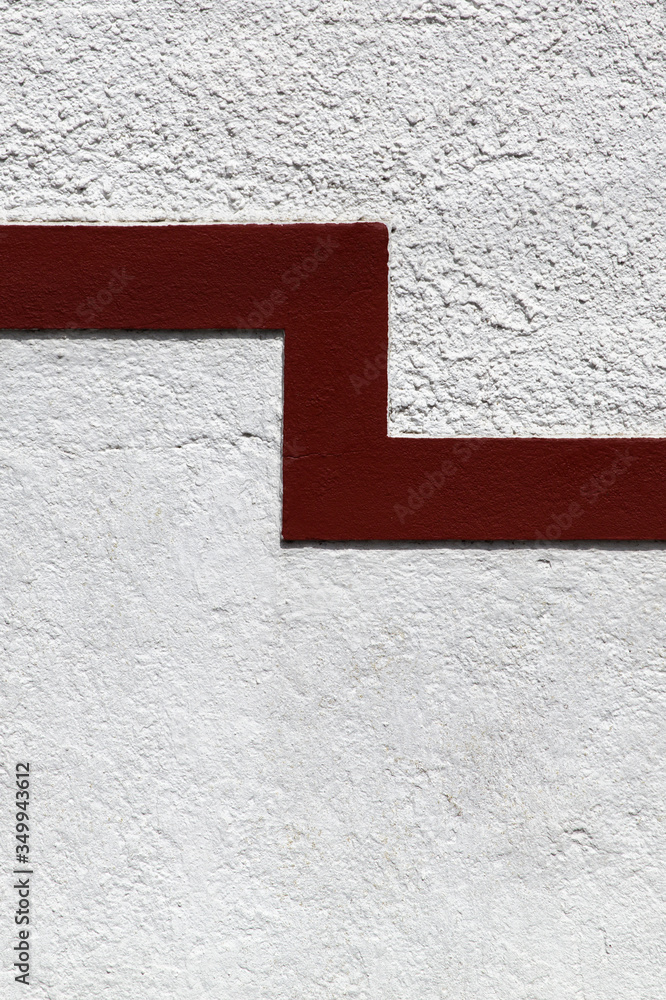 Red line on a white facade as a divider between grades of coarseness ...