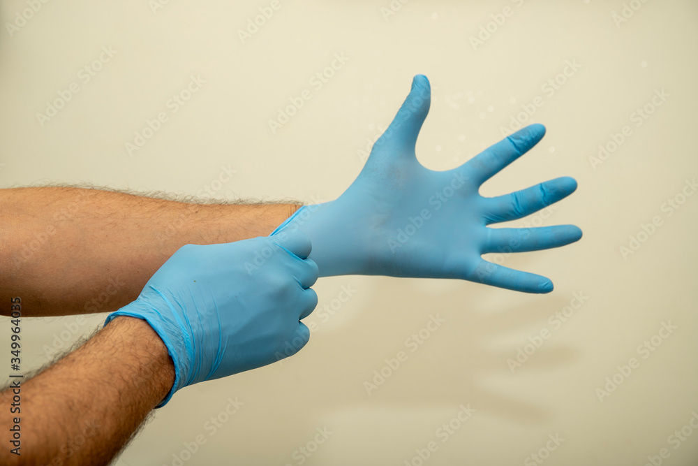 Put on the blue gloves. Hands of a man putting on gloves. Disposable ...
