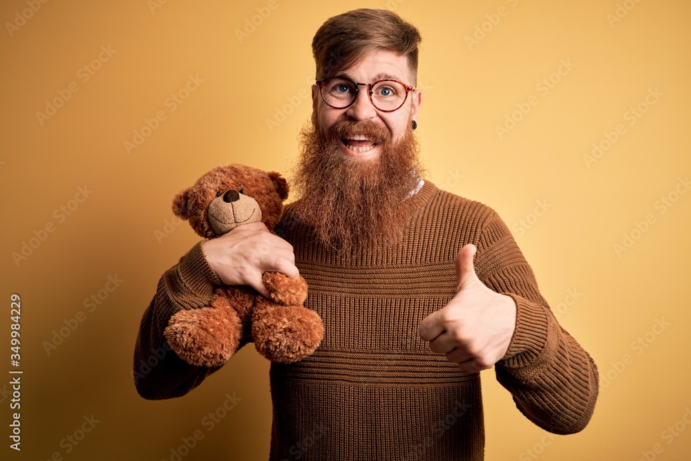 Redhead Irish man with beard hugging teddy bear stuffed animal over ...