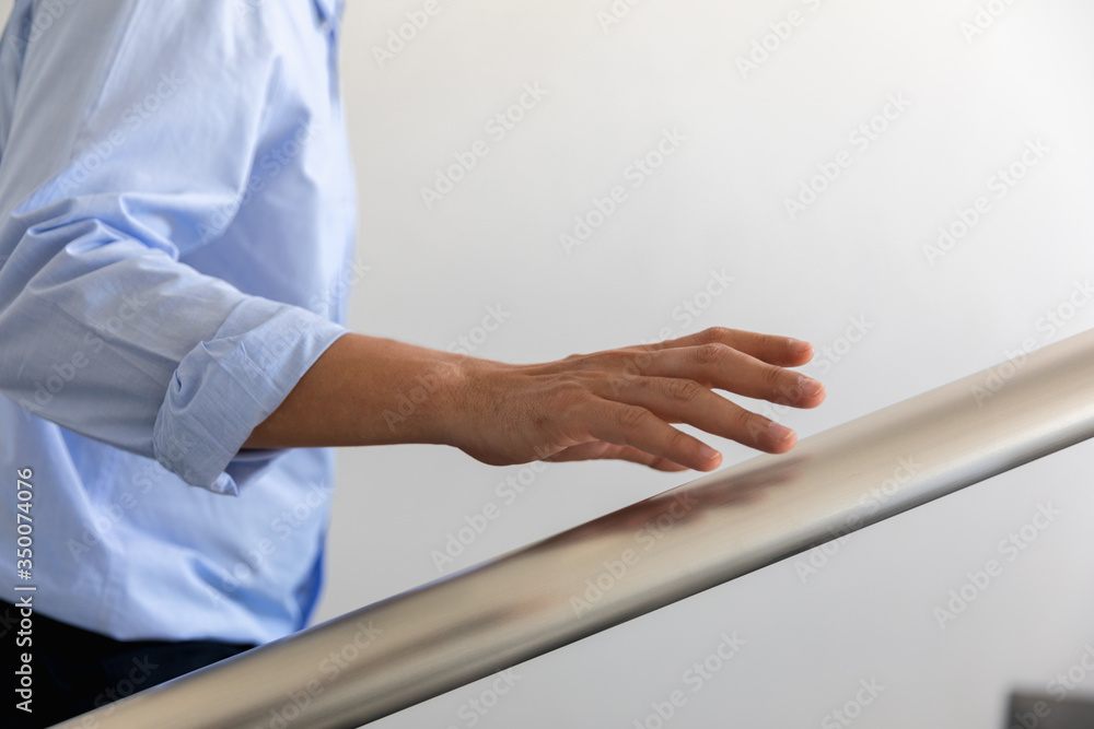 Hand holding banisters, The germ spread from person to person through ...