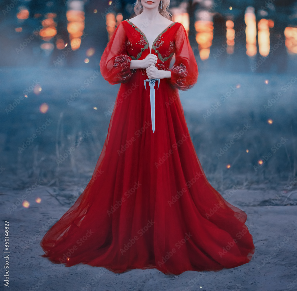 A mysterious blond woman holds a dagger of beautiful Gothic design in ...