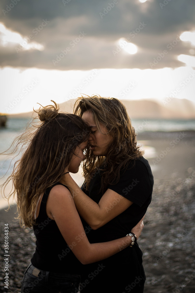 Pareja de dos chicas morenas jóvenes que son novias lesbianas besándose ...