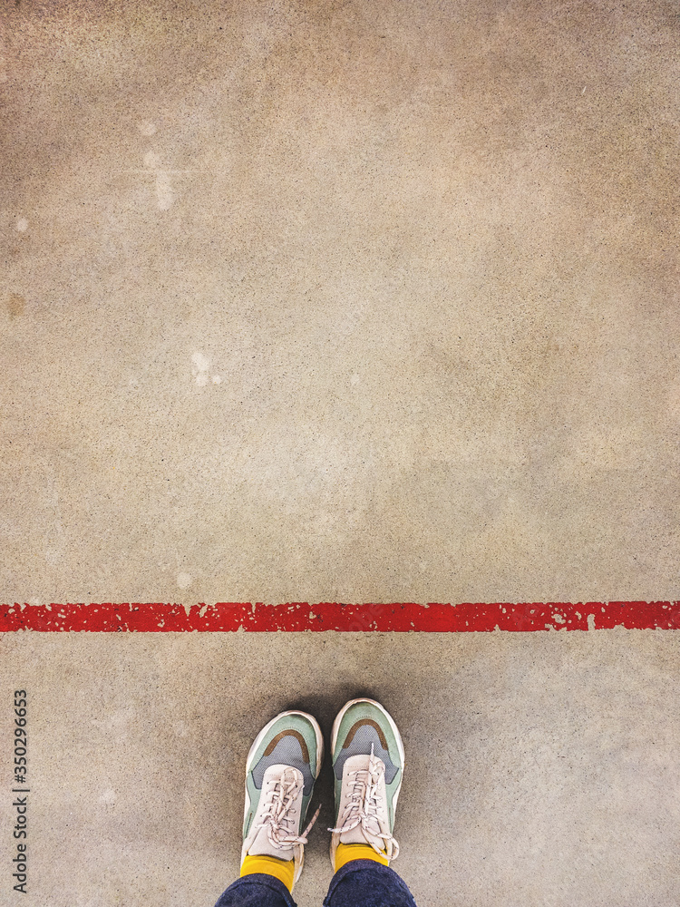 Person standing on red line - social distancing sing as a new normal ...