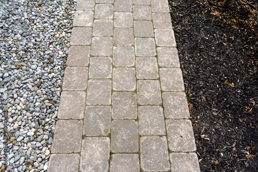 Tumbled paver walkway with wood chip and pea gravel mulches create a ...