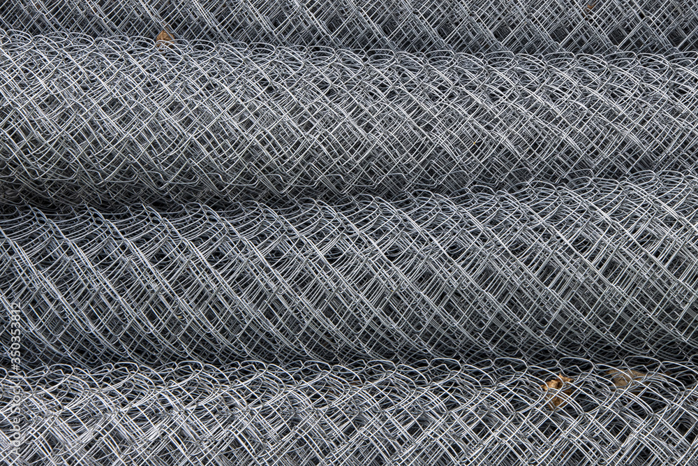 The metal mesh is twisted into rolls, large cells. Fencing net, fence ...