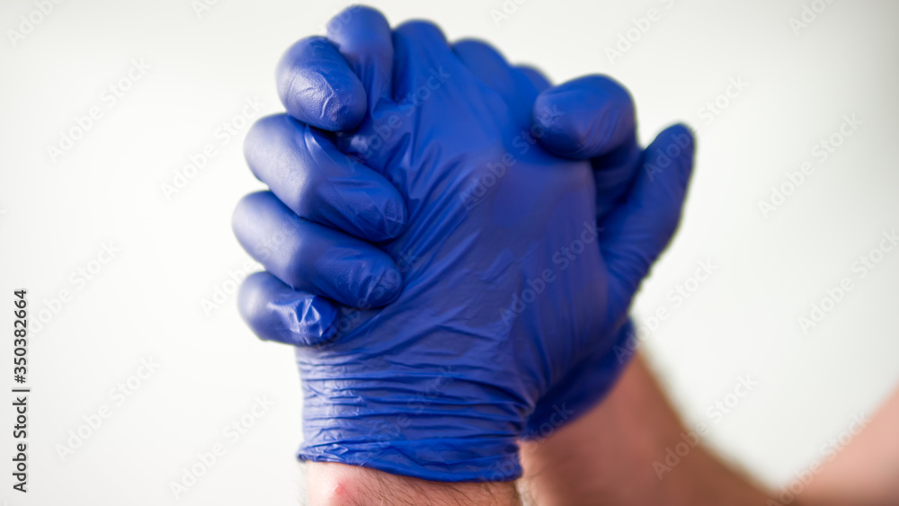 Body language,a doctor in rubber gloves squeezes two hands.On white ...
