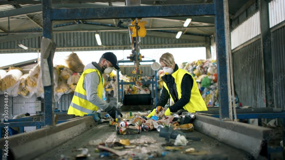 Man and woman workers on landfill, waste management and environmental ...