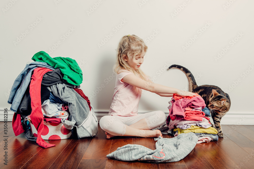 Mommy little helper. Cute Caucasian girl sorting clothes. Adorable ...
