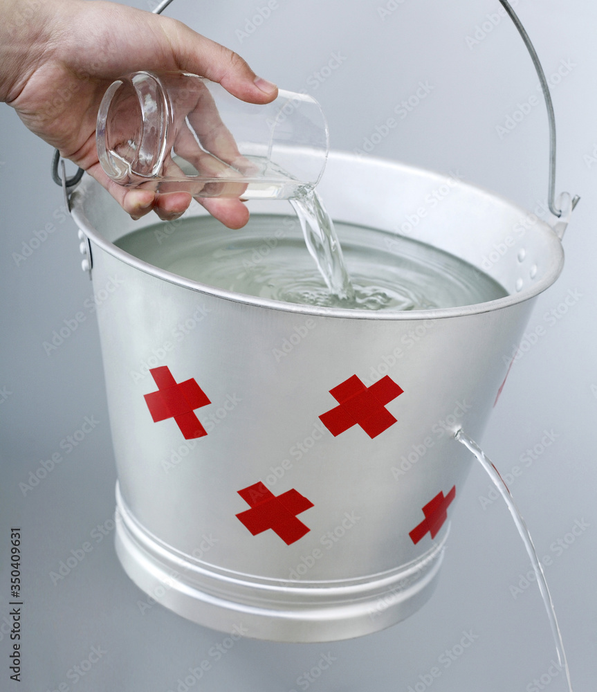 Hand pouring water from a glass into a leaking pail Stock Photo | Adobe ...