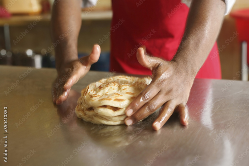 Man loosening the texture of roti canai to make them tastier Stock ...