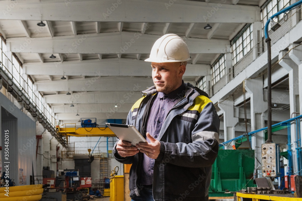 Engineer in a modern factory. The photo illustrates new technologies ...
