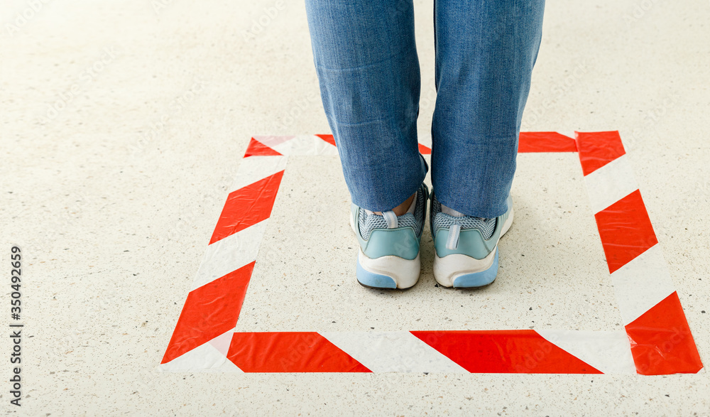 Red striped line sign for keeping social distance. Woman standing ...