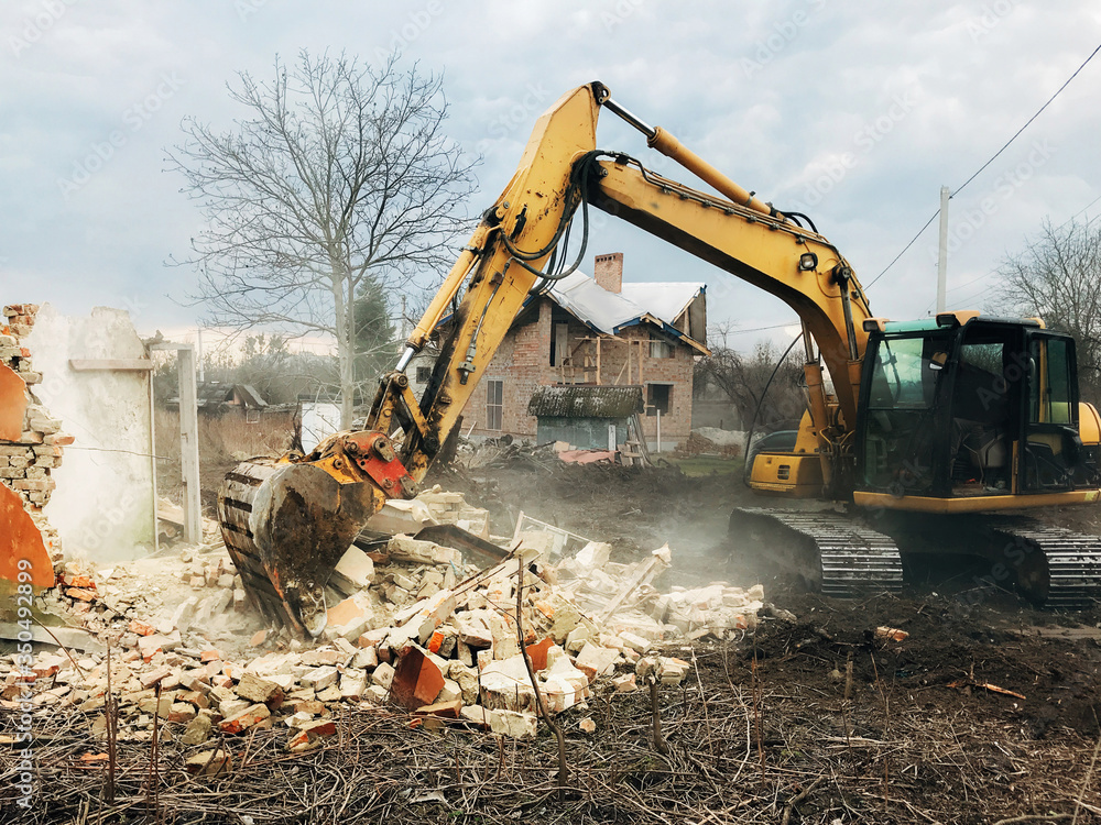 House crushing and collapse. Excavator destroying brick house on land ...