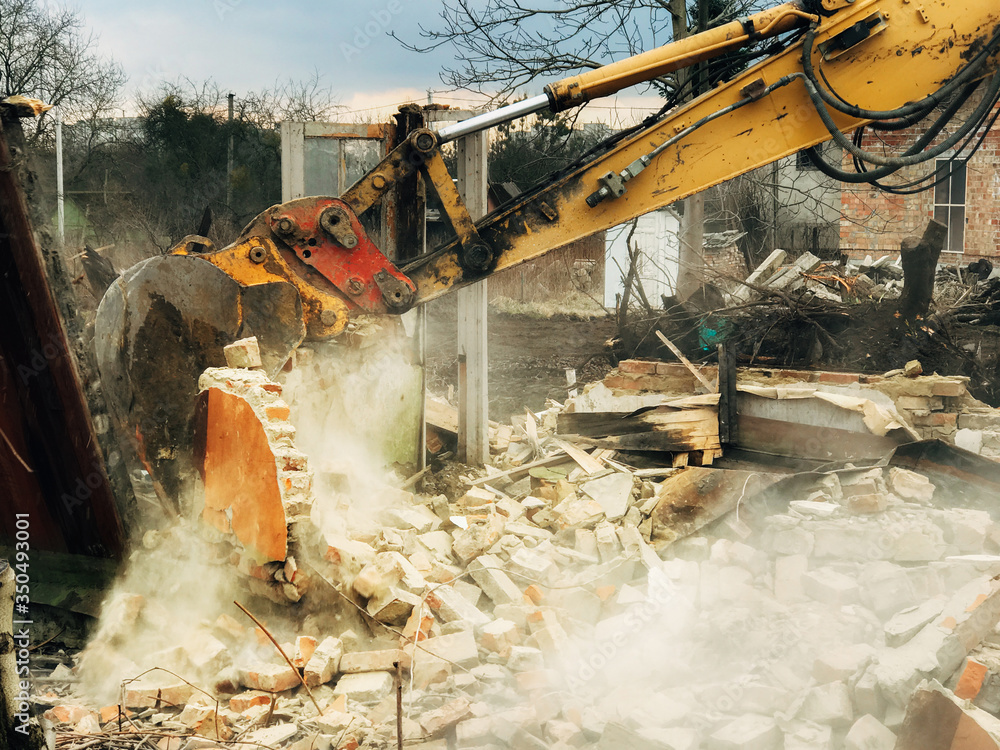 House crushing and collapse. Excavator destroying brick house on land ...