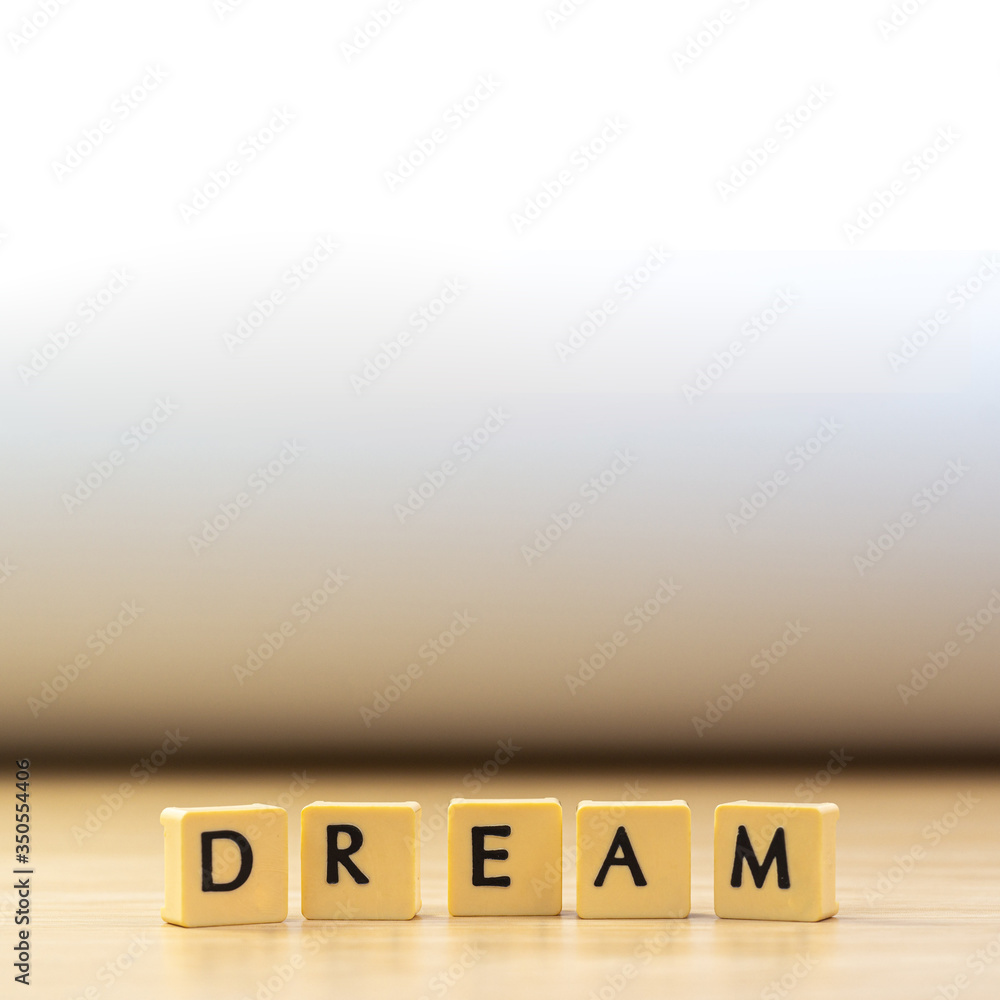 dream word written in cube on wooden floor on white background, letter ...
