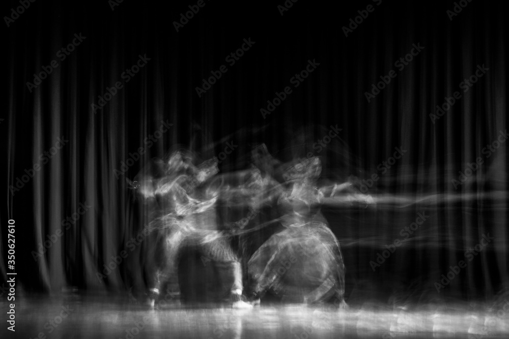 An artistic dancer in a theater shot with a slow shutter speed in order ...