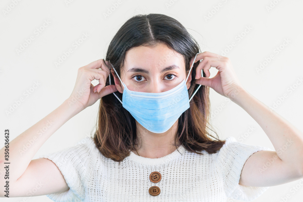 young beautiful asian woman showing how to wear a medical mask or ...