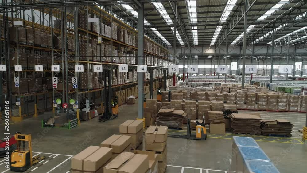 Interior of large stock warehouse with multiple shelves and stacks of ...