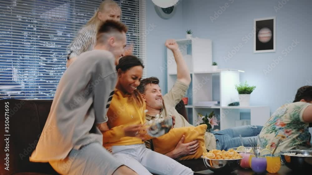Happy viewers watching sports on TV and spilling popcorn when team ...