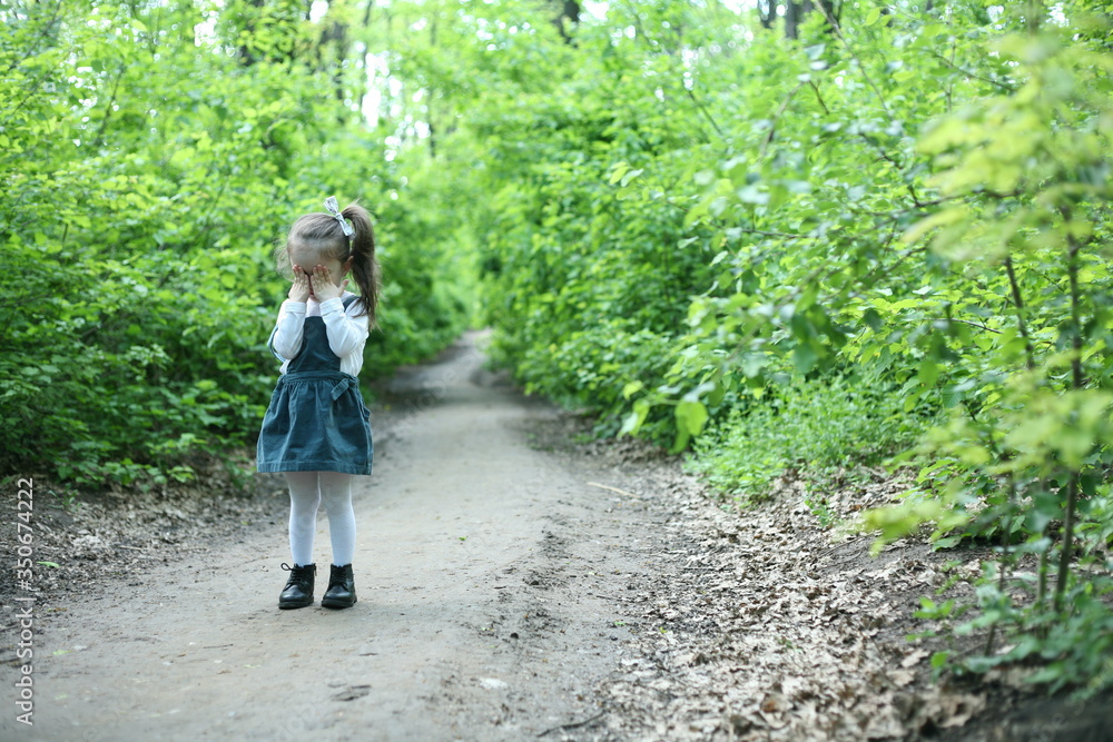Тhe little girl was lost alone in the forest. Child alone in the forest ...