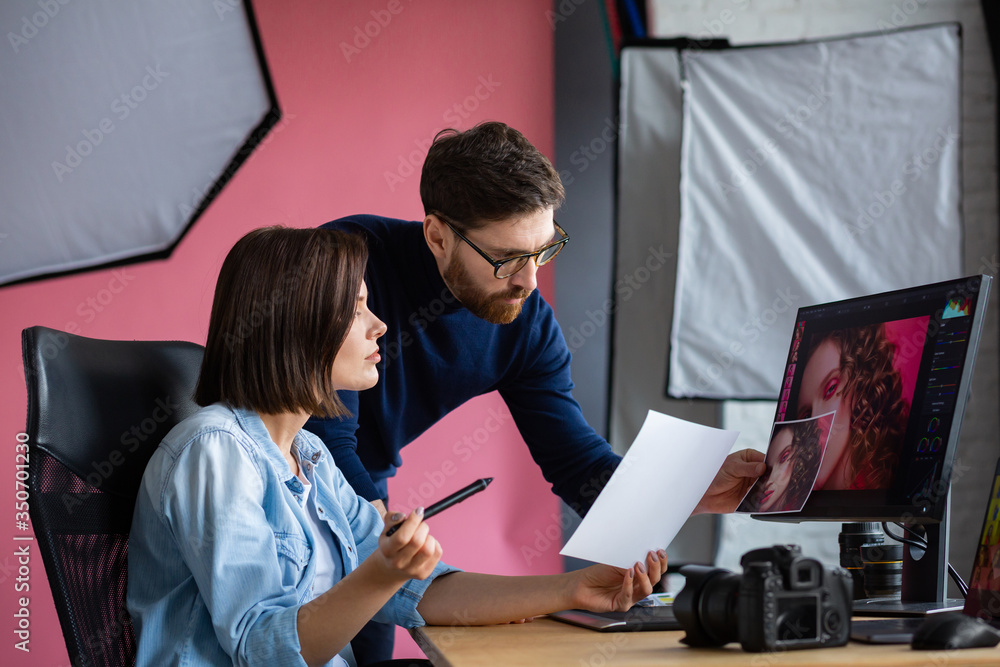 Photographer and graphic designer working in office with laptop ...
