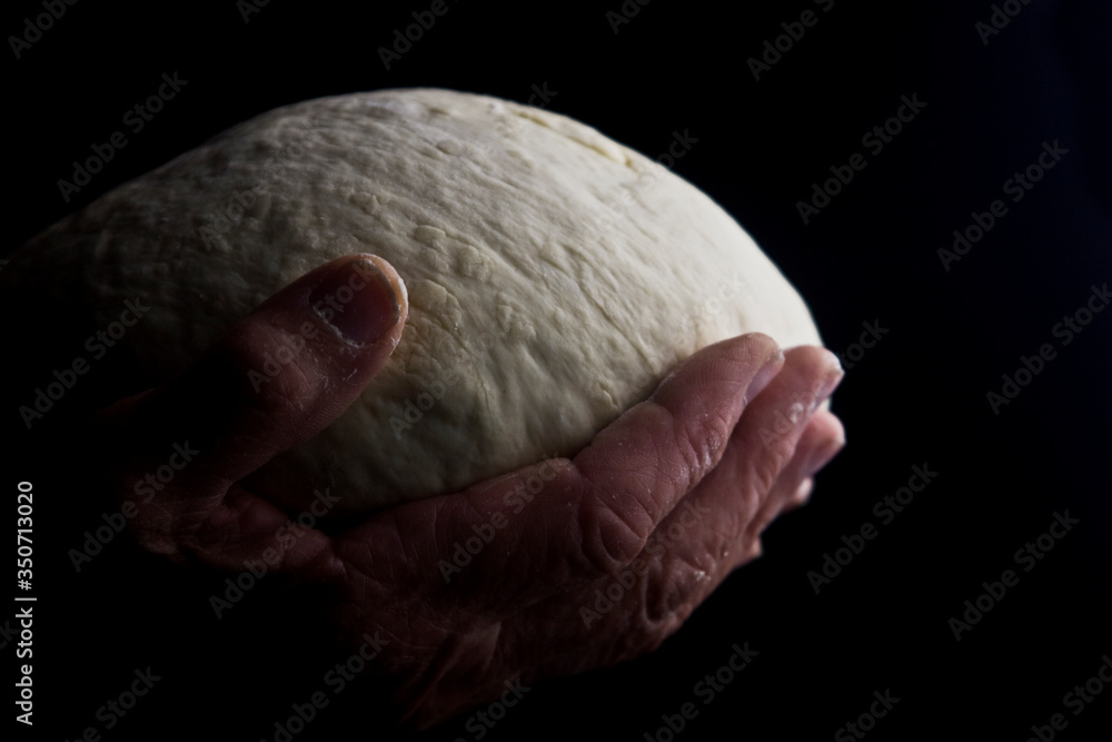 Bread in the old wrinkled hands of the grandmother close-up ...