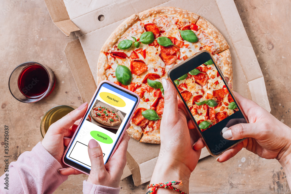 Female friends using smartphones to take photos of their pizza ...