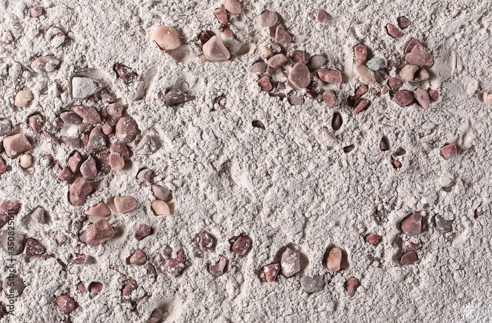 Dry cement, mortar powder pile, plaster surface with red rocks ...