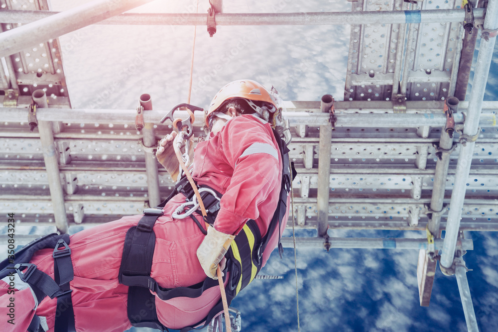 Male rope access construction worker wearing safety harness, fall ...
