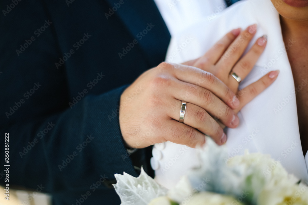 The joined hands of the bride and groom at a wedding. Wedding rings on ...
