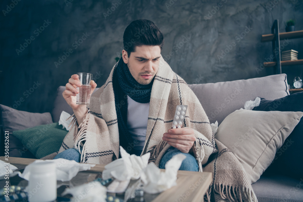 Portrait of his he nice attractive sick guy sitting on divan taking ...