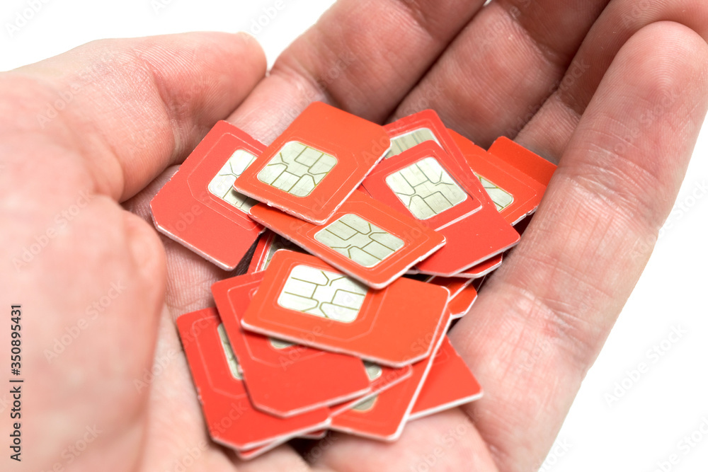 Many red telephone SIM cards are in the palm of the hand. Cards with ...
