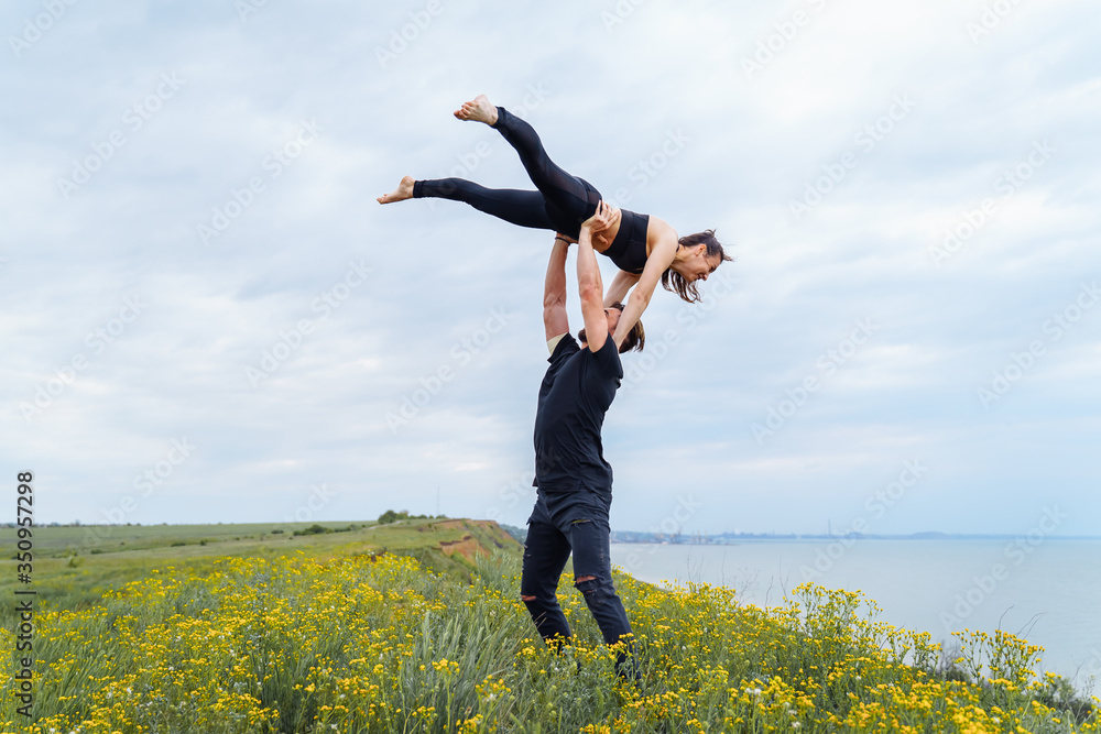 Lifestyle acroyoga and yoga poses. Pair of sportsman and sportswoman ...