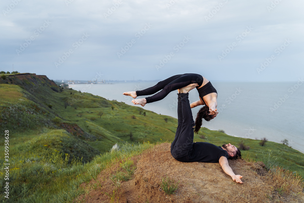 Acro yoga concept. Couple of young sporty people practicing yoga pair ...