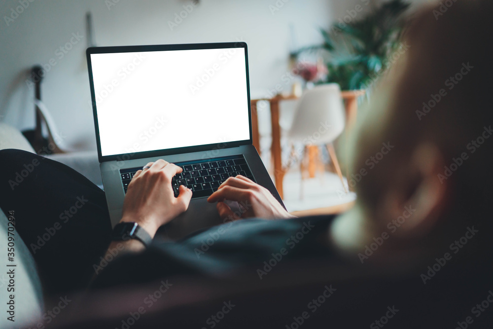 Young man using modern laptop device with blank screen with copy space ...