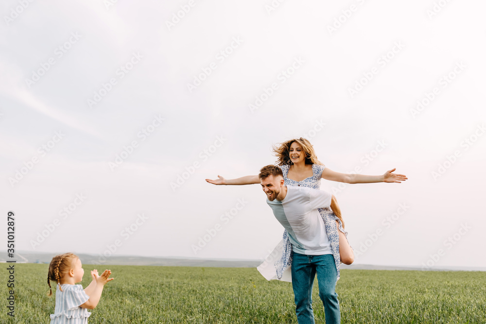 Young couple of man and woman playing in an open field, outdoors, on ...