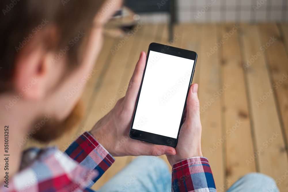 Mockup image: man looking at black smartphone with white blank screen ...